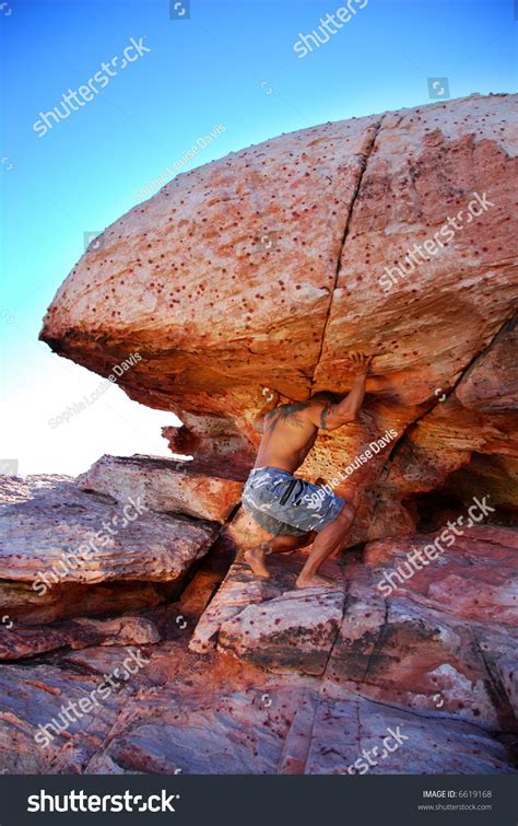 Muscular Man With Tattoos Pushing Up On A Massive Boulder Stock Photo Shutterstock
