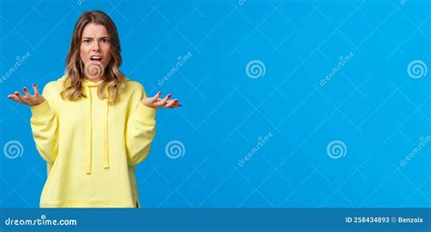 Frustrated And Displeased Confused Young Blond Girl Shrugging Looking