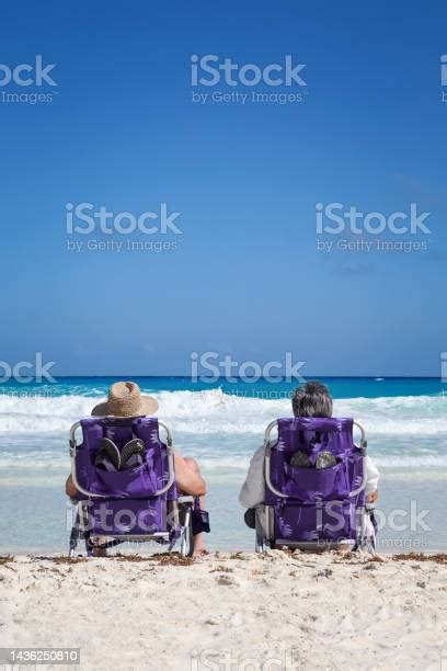 밀짚모자를 쓴 알아볼 수 없는 두 사람이 카리브해 해변의 의자에 앉아 바다를 바라보고 있다 2명에 대한 스톡 사진 및 기타 이미지 2명 등 라운지 의자 Istock