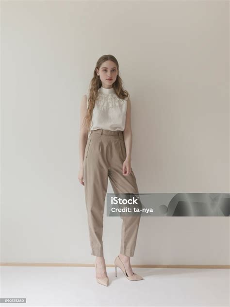 아름다운 젊은 여자 에 세련된 캐주얼 옷 빈티지 화이트 셔츠 베이지 색 바지 전체 길이 샷 여자에 대한 스톡 사진 및 기타 이미지 여자 바지 의복 베이지 Istock