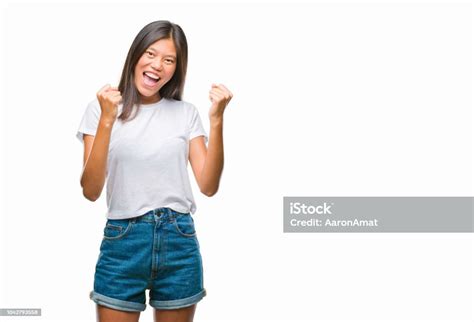 젊은 아시아 여자 격리 된 배경에 매우 행복 하 고 흥분 무기와 우승자 제스처를 하 고 웃 고 성공을 위한 비명 축 하 개념입니다 긍정적인 감정 표현에 대한 스톡 사진 및