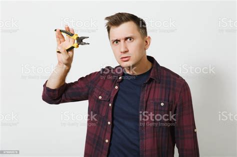 잘생긴 심각한 백인 젊은 남자가 격자 무늬 빨간색 셔츠 흰색 배경에 고립 된 보편적인 펜을 들고 있다 광고에 대 한 공간을 복사 합니다 T 셔츠에 대한 스톡 사진 및 기타