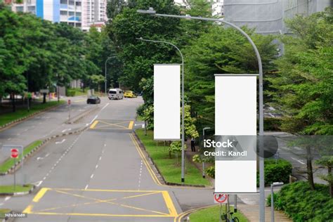도시의 길가에 포스터를 걸고 가로등 기둥에 무성한 녹색 나무와 식물에 대한 빈 수직 광고 배너 Ooh의 경우 집 템플릿 모형 배너 표지판에 대한 스톡 사진 및 기타 이미지