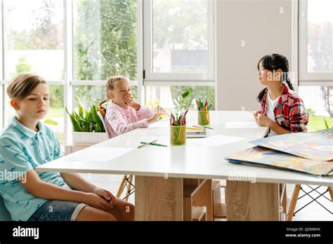 Multiracial Pupils Drawing During Class In Art School Indoors Stock