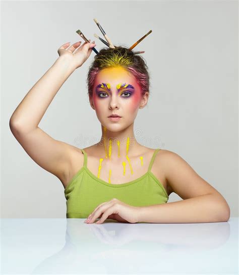 Portrait Of Young Woman Posing At The Table With Brushes In Hair Stock