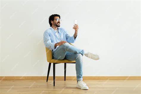 Premium Photo Cheerful Millennial Middle Eastern Guy Blogger In Glasses Has Video Call