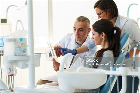 치과 의사와 치과 진료소의 조수는 젊은 여성 환자와 이야기하고 치료를 준비합니다 치과에 대한 스톡 사진 및 기타 이미지 치과 건강 진단 건강관리와 의술 Istock