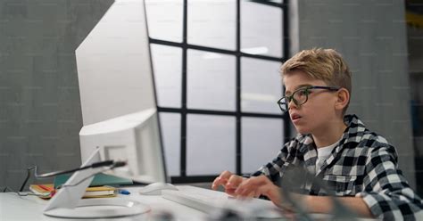 학교 교실에서 컴퓨터를 사용하는 남학생 사진 Unsplash의 앉아 이미지