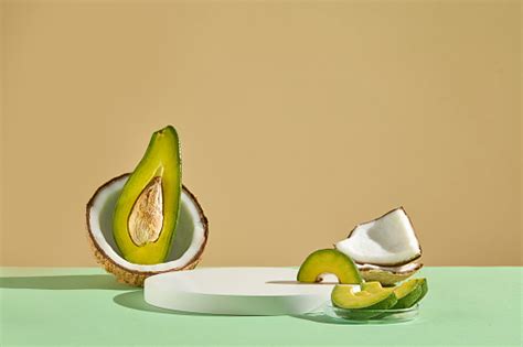 노란색 질감 위에 아보카도와 코코넛 옆에 녹색 테이블 위에 놓인 둥근 모양의 흰색 빈 플랫폼 사진은 화장품을 전시할 수 있는 빈 공간이 있는 정면에서 촬영한 것입니다 0명에