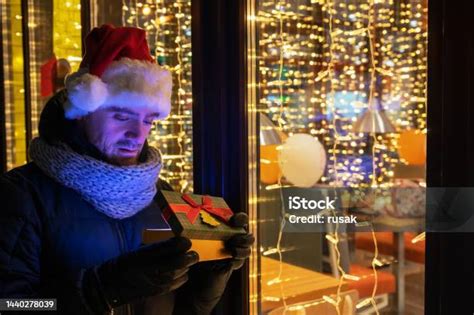 산타 모자를 쓴 남자가 조명이 켜진 상점 창문을 보고 꿈꾸는 모습 12월에 대한 스톡 사진 및 기타 이미지 12월 35 39세 강림절 Istock