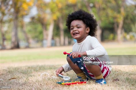 공원에서 장난감을 연주하는 아프리카 계 미국인 어린 소년 곱슬 머리를 가진 아이들은 야외에서 재미있게 지내세요 외부를 즐기는