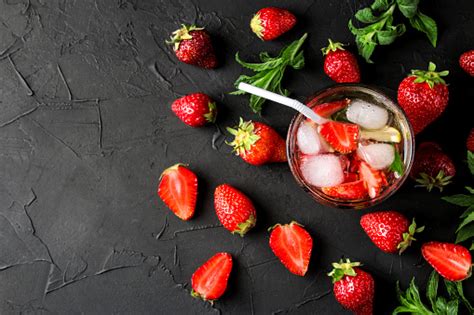 딸기 모히토 차가운 여름 모히토 칵테일딸기 민트 레몬 얼음을 검은 테이블에 잔에 새겨 서 여름 상쾌한 음료 맨 위 보기 쿠바