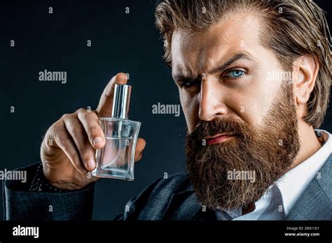 Masculine Perfume Male Fragrance And Perfumery Cosmetics Bearded Man Holding Up Bottle Of