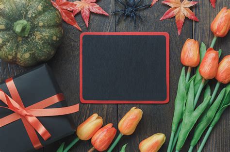 테이블 탑의 장식 기호 해피 할로윈 축제 배경 아름 다운 오렌지 튤립과 단풍나무 잎 소박한 현대 나무 책상에 혼합 개체입니다 텍스트 정보에 대 한 공간을 복사 합니다 어두운