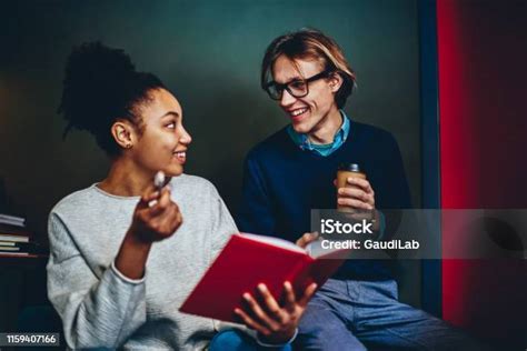 행복한 다양성 친구는 자유 시간에 메모장에 기록 된 아이디어를 서로 이야기 대화를 즐기는 일반적인 프로젝트에 대해 의사 소통 쾌활한 다민족 남성과 여성 동료 2명에 대한