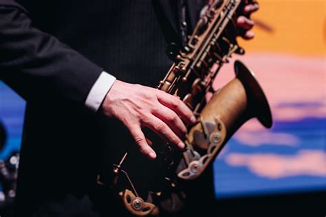 색소폰 연주자 음악가 색소폰 색소폰 연주자 보컬리스트와 뮤지컬 밴드와 함께 재즈 오케스트라 쇼 중 무대에서 음악을 연주하는 장면 조명 뮤지컬 클럽 홀에서 콘서트 전경