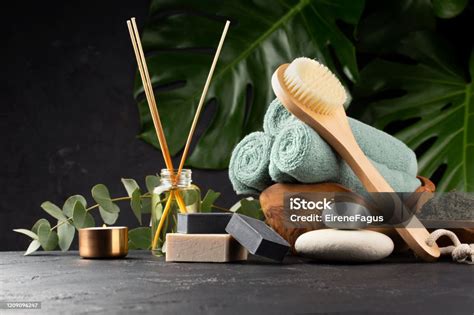 스파와 목욕 컨셉 녹차 스크럽 석탄 검은 비누 유칼립투스 오일 바다 돌 수건 및 열대 잎과 검은 배경에 바디 브러시 공간을 복사합니다 에센셜 오일에 대한 스톡 사진 및 기타