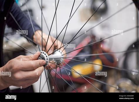 Unrecognizable Man Assembling A Bike Wheel Axle After Disassembling It