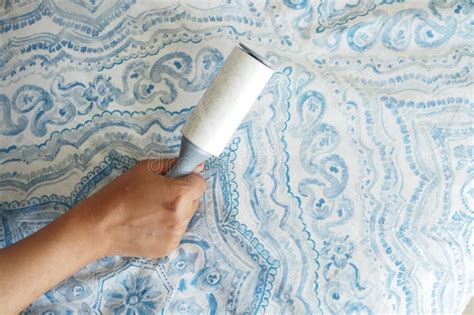 Using An Adhesive Roller To Remove Lint And Fluff From A Bed Stock