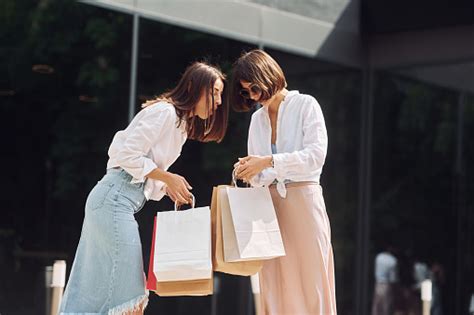 긍정적 인 구매자 두 명의 여성 친구가 쇼핑의 날을 보낸다 가방으로 야외에서 걷기 25 29세에 대한 스톡 사진 및 기타 이미지 25 29세 2명 가방 Istock