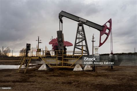 빔 펌핑 유닛은 숙제 오일 필드의 일몰입니다 석유 펌프 오일 장비 에너지 산업 기계 펌프가 우물에 설치 된 펌핑 장치 오일 분야의 장비 강철에 대한 스톡 사진 및 기타