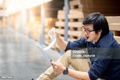 종이 클립보드를 사용 하 여 창 고 선반에 골 판지 상자에 제품의 재고 조사 생각 하 고 젊은 아시아 남자 실제 재고 카운트 개념 검사 보기에 대한 스톡 사진 및 기타