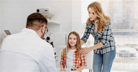 가족 지원 사랑하는 엄마와 그녀의 예쁜 딸은 안과 의사 사무실에 앉아 여자 테스트 결과를 연구하는 동안 그의 평결을 기다리고 있습니다 사진 Unsplash의 안과 이미지