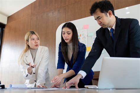 Team Of Professionals Analyzing Financial Reports And Charts During A Strategic Meeting Stock