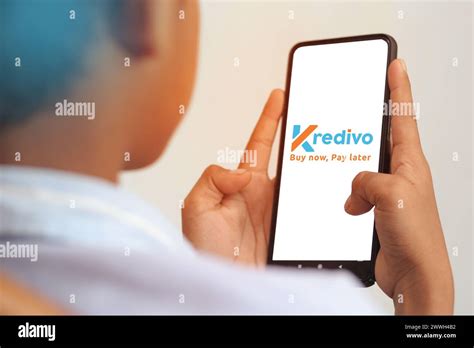 Teenagers Holding Cellphones Displaying The Kredivo Application On