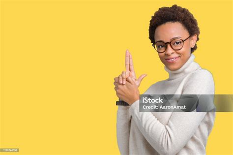 젊은 아름 다운 아프리카계 미국인 여자 손 제스처와 함께 상징적 총을 들고 고립 된 배경 안경을 착용 살인 촬영 무기를 재생 화난 얼굴 손가락에 대한 스톡 사진 및 기타