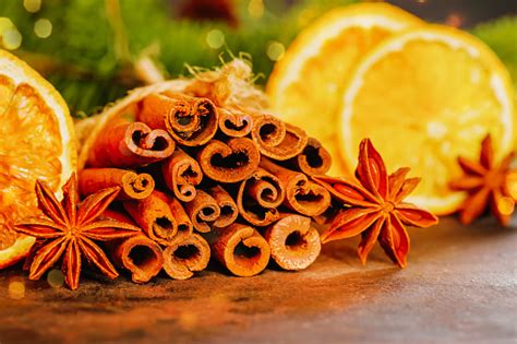 계피 스틱 스타 아니스 가을과 겨울 온난화 음료를 준비하기위한 말린 레몬 화환과 보케재료요리 크리스마스 장식을위한 크리스마스 트리의 배경에 대해 갈색에 대한 스톡 사진 및