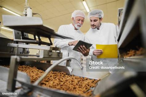 식품 공장 생산 라인 및 보고 및 태블릿 앞에 서 서 메 마른 옷에 두 비즈니스 사람 제품의 품질을 확인 하 고 이야기입니다 음식에 대한 스톡 사진 및 기타 이미지 Istock