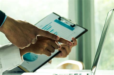 회의 판매에 대 한 요약 통계 지도 손에 들고 하는 동안 동료 들과 함께 일련의 그래프를 분석 하는 사업가의 측면 보기 공연에 대한 스톡 사진 및 기타 이미지 Istock