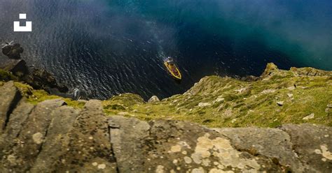 A Boat In A Body Of Water Surrounded By Rocks Photo Free Dingle