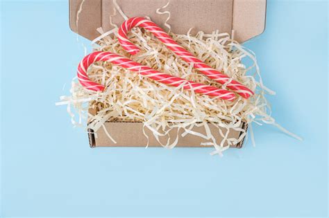 파란색 배경에 파쇄 된 종이와 크리스마스 롤리팝골판지 상자 패키지를 엽니 다 선물 공예 종이 상자 새해 와 크리스마스 휴일 갈기갈기 찢어진에 대한 스톡 사진 및 기타 이미지