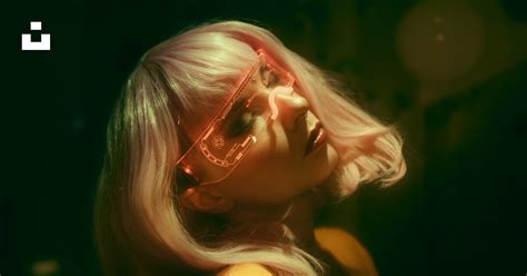 분홍색 머리와 안경을 쓴 여성이 스포트라이트를 받으며 포즈를 취하고 있습니다 사진 Unsplash의 무료 초상 이미지