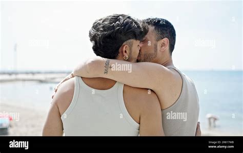 Two Men Couple Hugging Each Other And Kissing Backwards At Seaside
