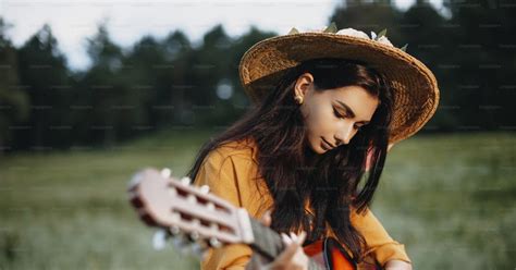 자연에서 기타를 연주하는 매력적인 젊은 여성의 야외 사진 사진 Unsplash의 예술 이미지