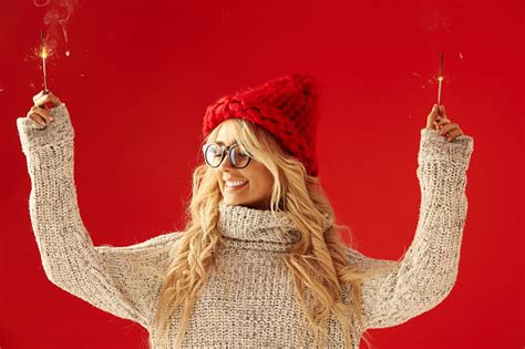 고립 된 빨간 배경에 미소 벵골 조명행복 한 여자 스웨터와 겨울 모자를 착용 축제 분위기를 표현한다 겨울에 대한 스톡 사진 및 기타 이미지 Istock