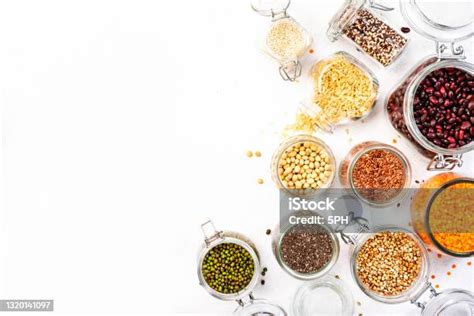 플라스틱 무료 저장 및 조리 개념 다양한 유기농 슈퍼푸드 콩 곡물 곡물 콩류 재사용 가능한 캔 및 항아리의 씨앗 흰색 테이블 제로 폐기물과 스스탠드 라이프 스타일 건강한