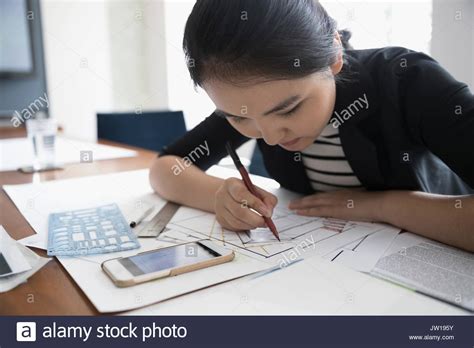 Dedicated Female Architect Drafting Blueprints In Conference Room Stock Photo Alamy