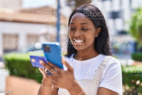 공원에서 스마트 폰과 신용 카드를 사용하는 젊은 아프리카 계 미국인 여성 Brand Name Mobile Payment에 대한 스톡 사진 및 기타 이미지 Brand