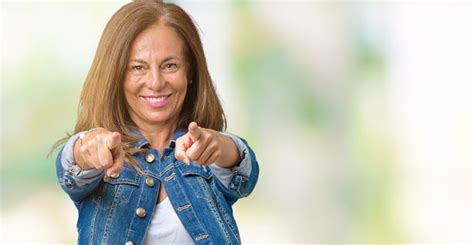 격리를 통해 캐주얼 데님 자 켓을 입고 아름 다운 중 년 여자 배경 당신에 게 패 니 얼과 손가락으로 카메라 긍정적이 고 밝은 미소 가리키기에 대한 스톡 사진 및 기타