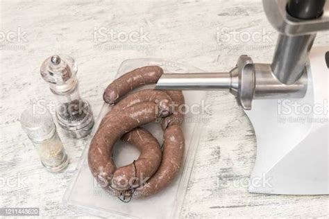 나무 테이블에 천연 껍질에 신선한 수제 쇠고기 소시지를 닫습니다 다진 고기와 향신료 항아리를 요리하기위한 고기 분쇄기 피크닉과 바비큐를 위한 빠르고 영양가 있는 음식 고기