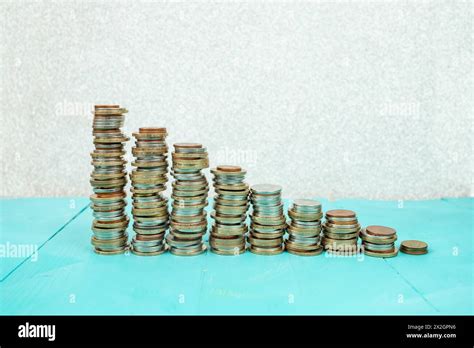 Stack Of Coins Bar Chart Graph Trending Downwards With White Wall