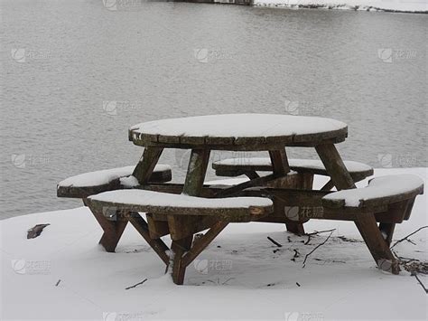 湖边铺满了雪的圆桌和长凳