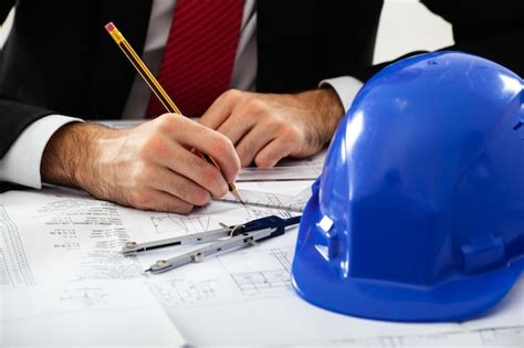 Premium Photo Architect Reviewing Blueprints At Work Desk