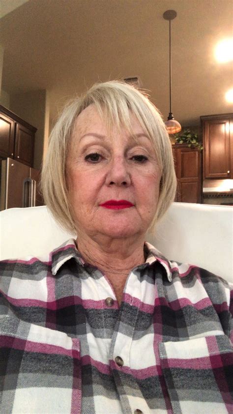 An Older Woman Sitting In A Chair With Her Eyes Closed And Looking At