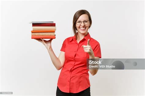 빨간색 셔츠 안경 손에 흰색 배경에 고립 된 스택 교과서를 들고 있는 아름 다운 젊은 비즈니스 교사 여자의 초상화 교육 또는 고등학교 대학 개념에서 교육입니다 9월에 대한