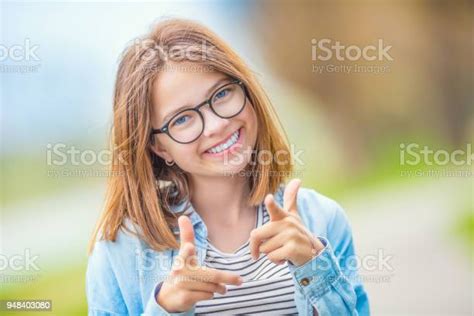 안경와 아름 다운 미소를 당신에 게 보여주는 열정으로 행복 Smilling 십 대 젊은 여자의 초상화 가리키기에 대한 스톡 사진 및 기타 이미지 Istock